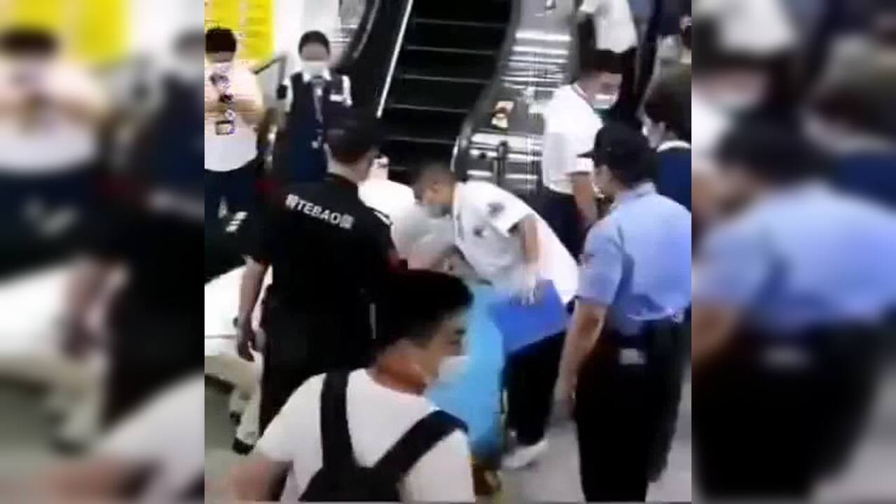 Caught on camera: Woman on escalator gets knocked off by a falling ...