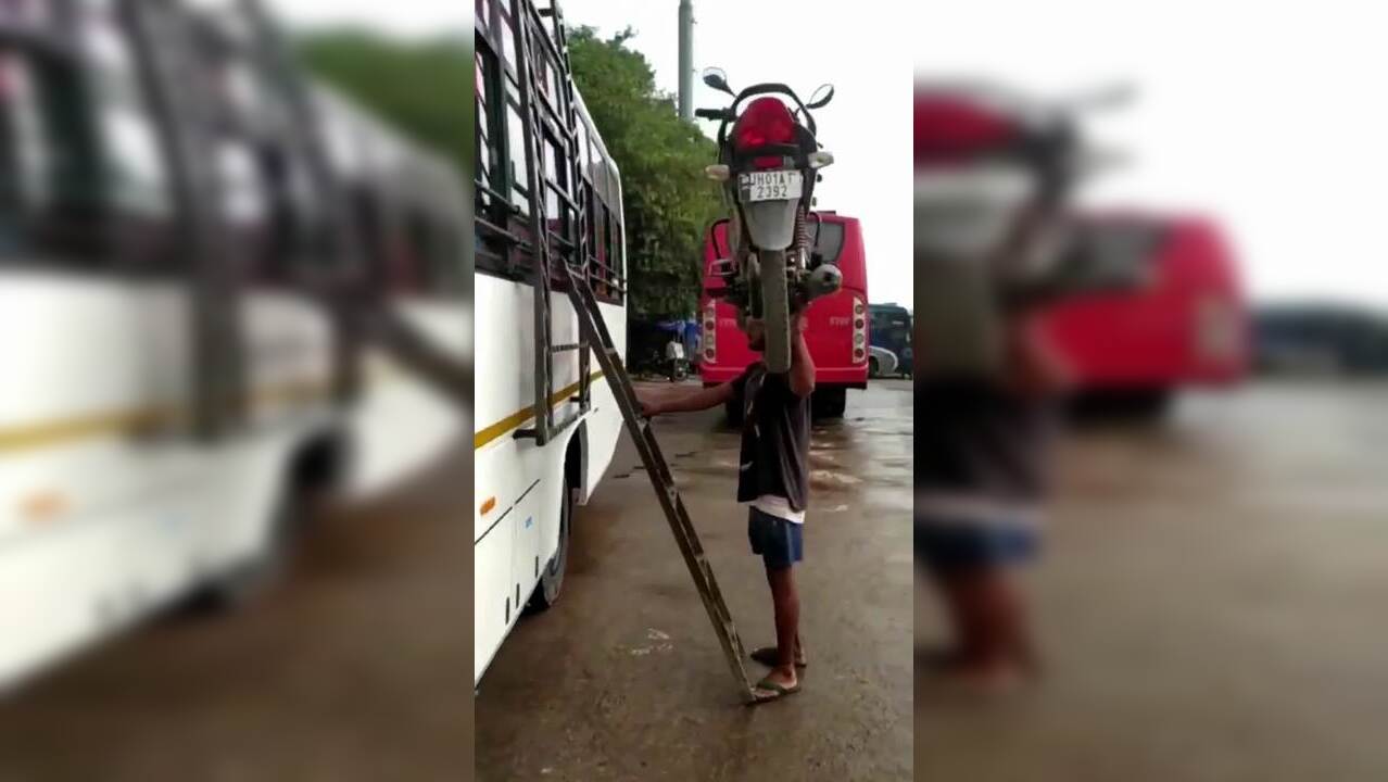 Man carrying bike on head| Man climbs up ladder with motorcycle on his ...