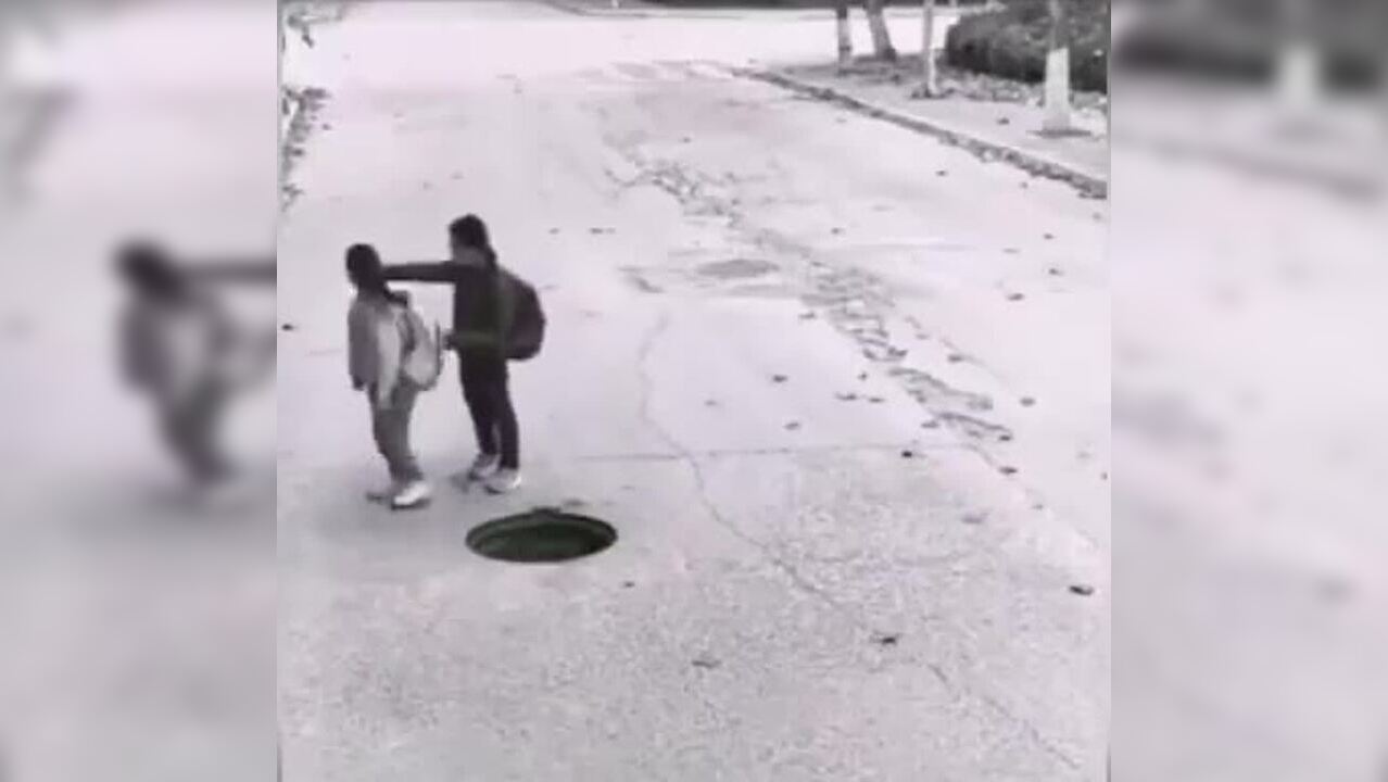 Two school kids leave the internet impressed by covering a manhole on a ...