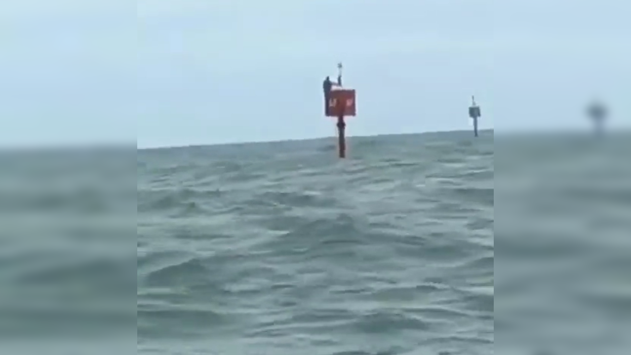 Clip emerges of man hanging from a navigation marker; he survived two ...