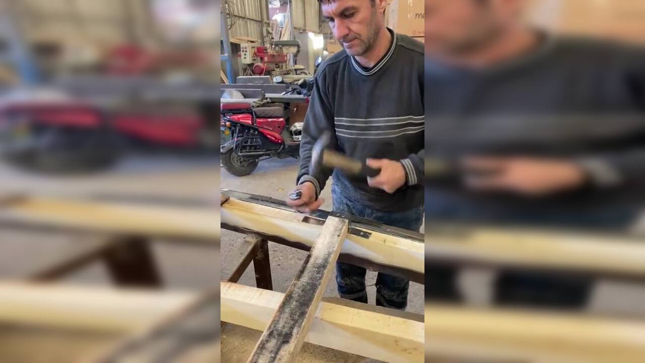 Man's incredible eye-hand coordination while nailing metal sheet to ...
