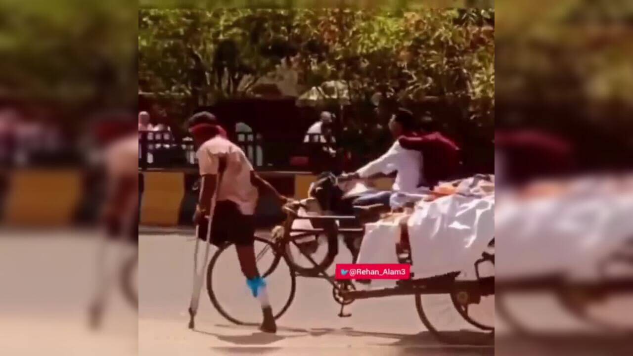 Specially-abled man pulls cart with one hand, holds crutch with other ...